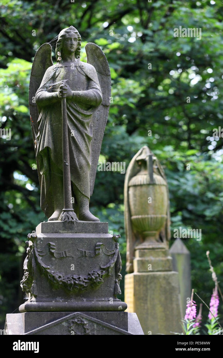 A statue of an angel sitting on top of a grave in the grounds of Dalry ...
