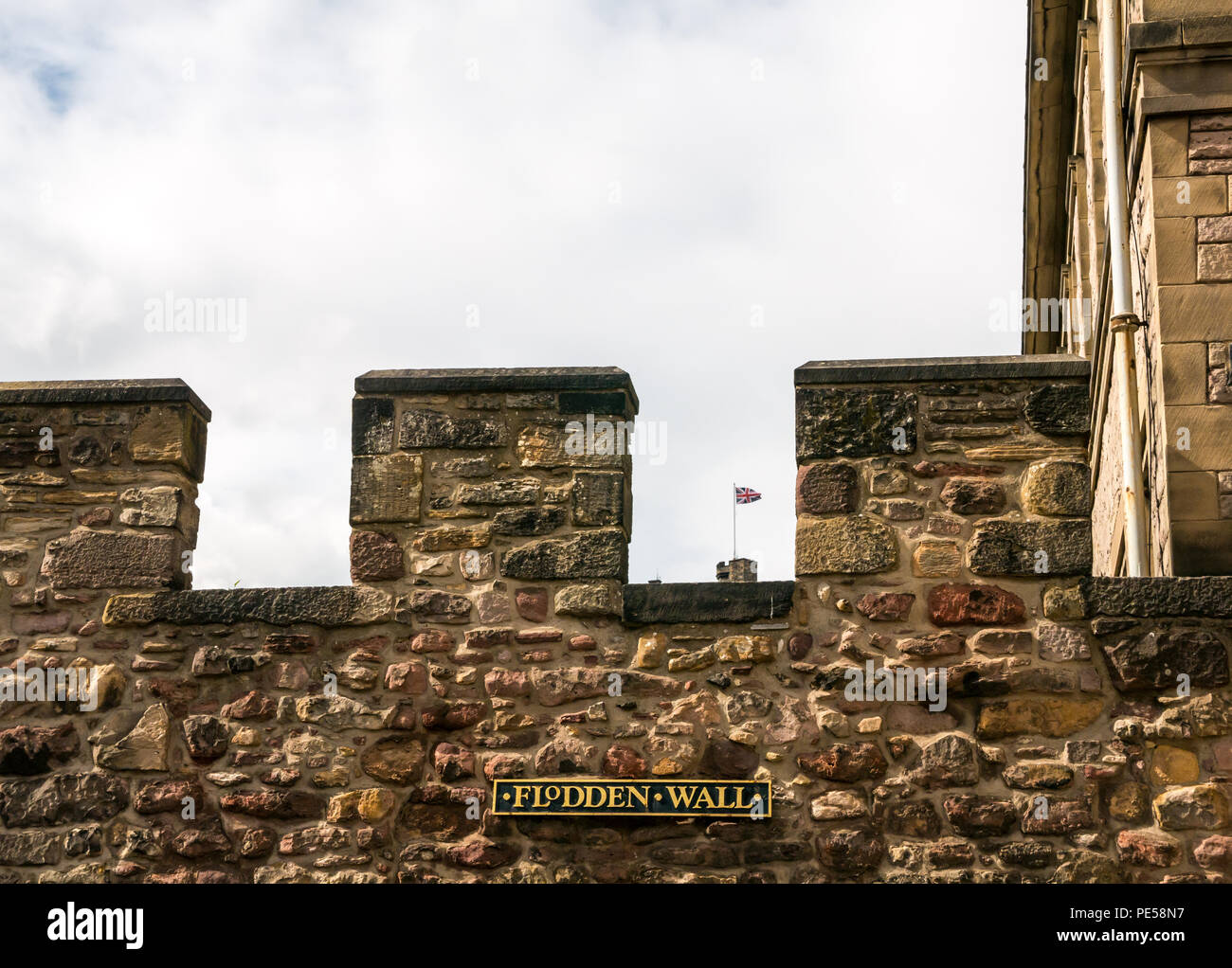 16th century defensive Flodden Wall with sign and Union Jack flag ...