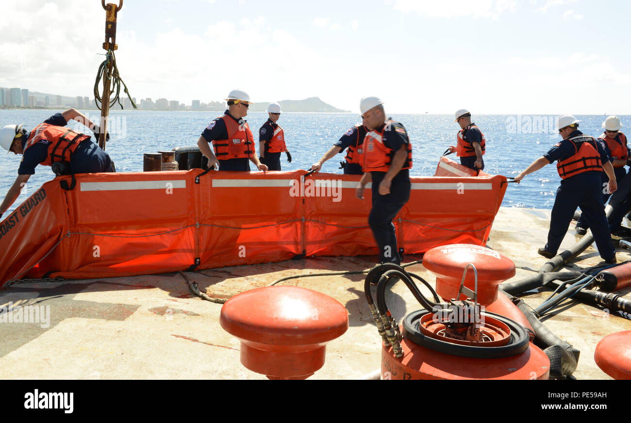Coast Guardsmen pull in boom after conducting a training evolution to ...