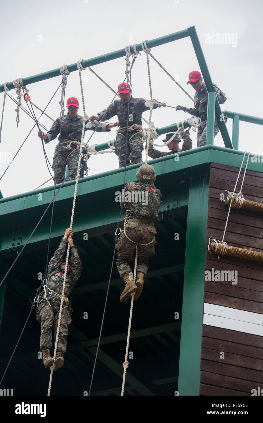 U.S. Marine Lance Cpl. Miller T. Crosby, bottom right, climbs up a rope ...