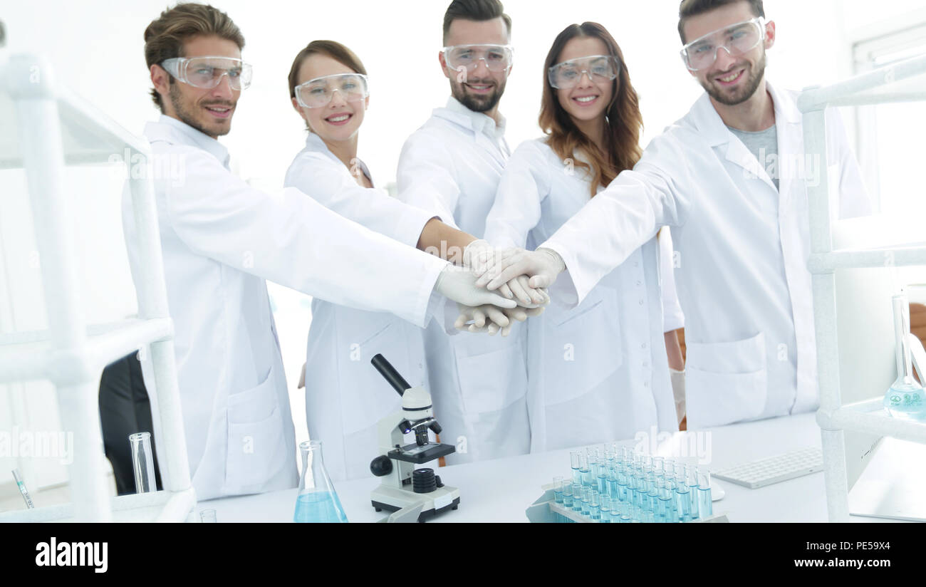 successful team of young scientists with hands clasped together Stock ...