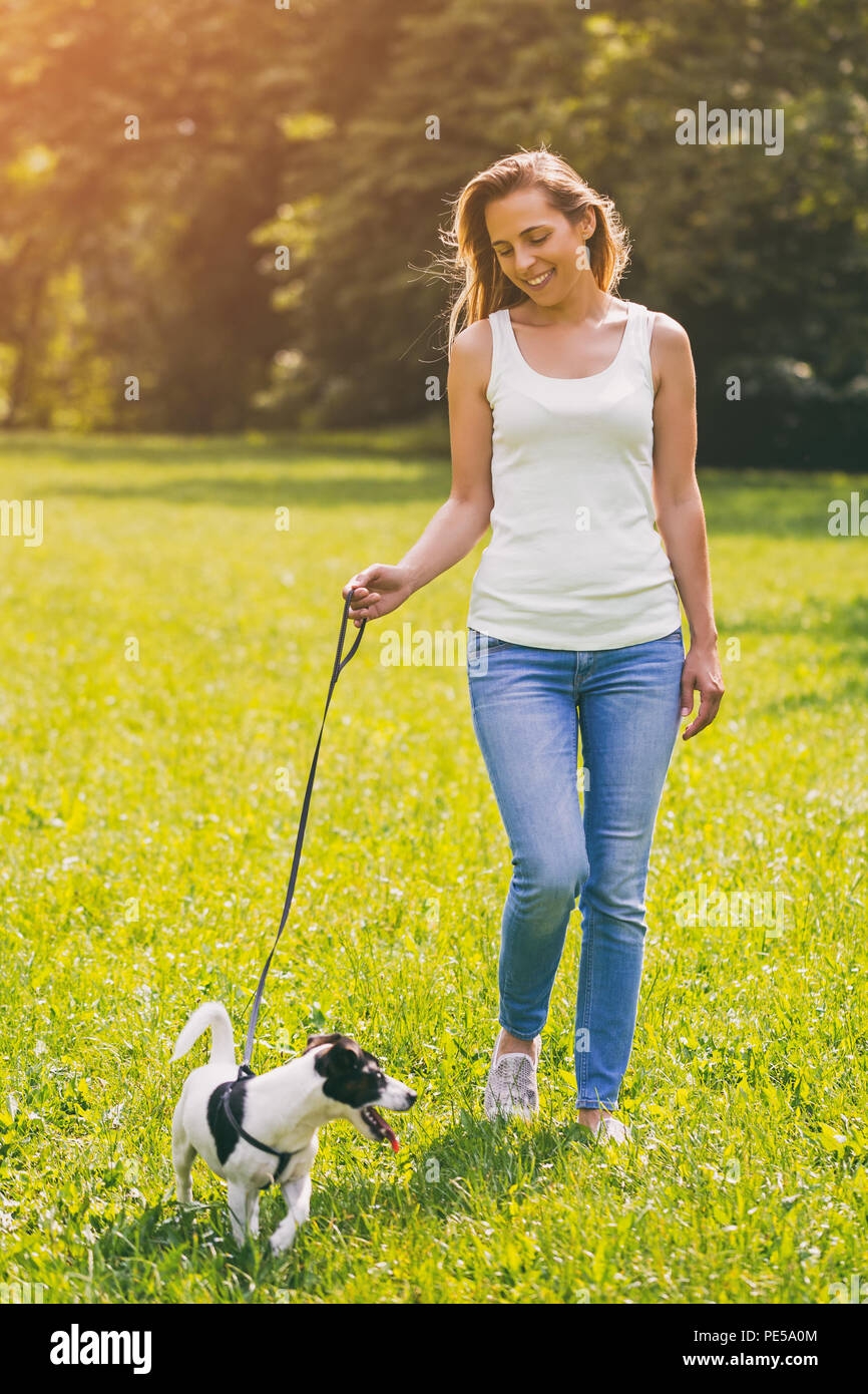 Woman walking small dog park hi-res stock photography and images - Alamy