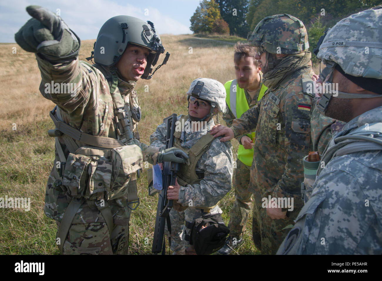 Multinational soldiers receive instructions from a helicopter crew ...