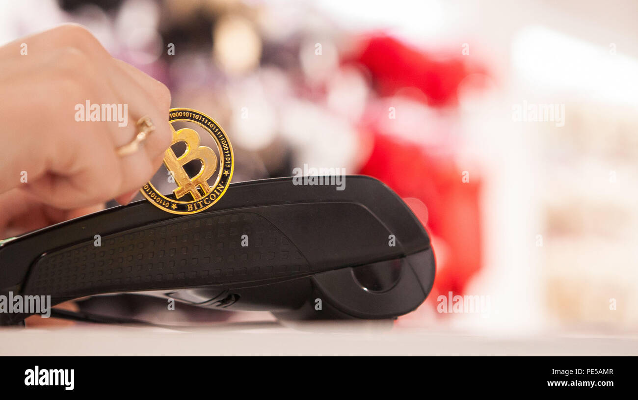 Bitcoin, credit card and POS-terminal. The golden bitcoin in female ...