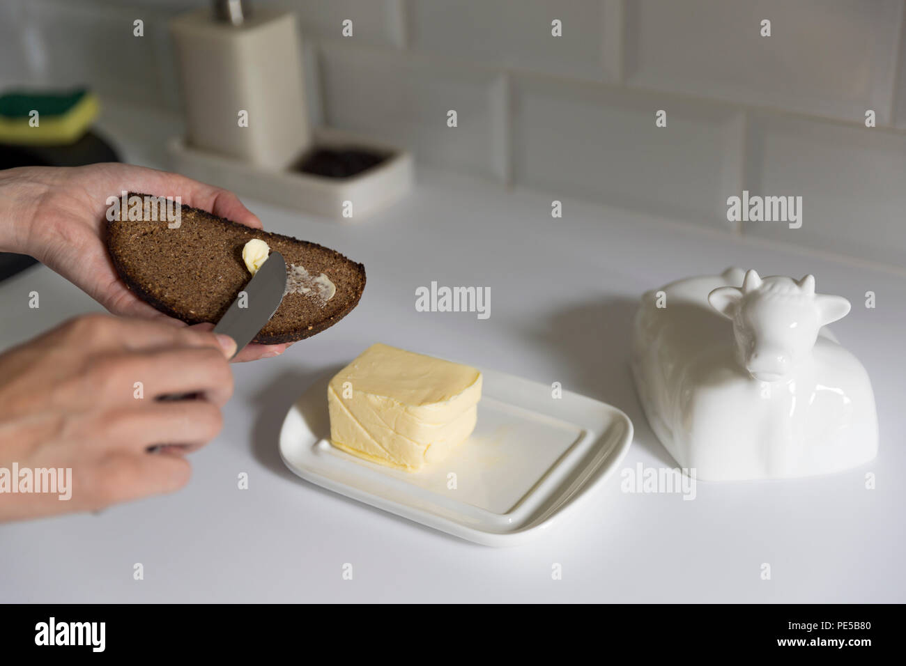 Woman smears butter with a knife on bread. A Healthy Eating Concept ...
