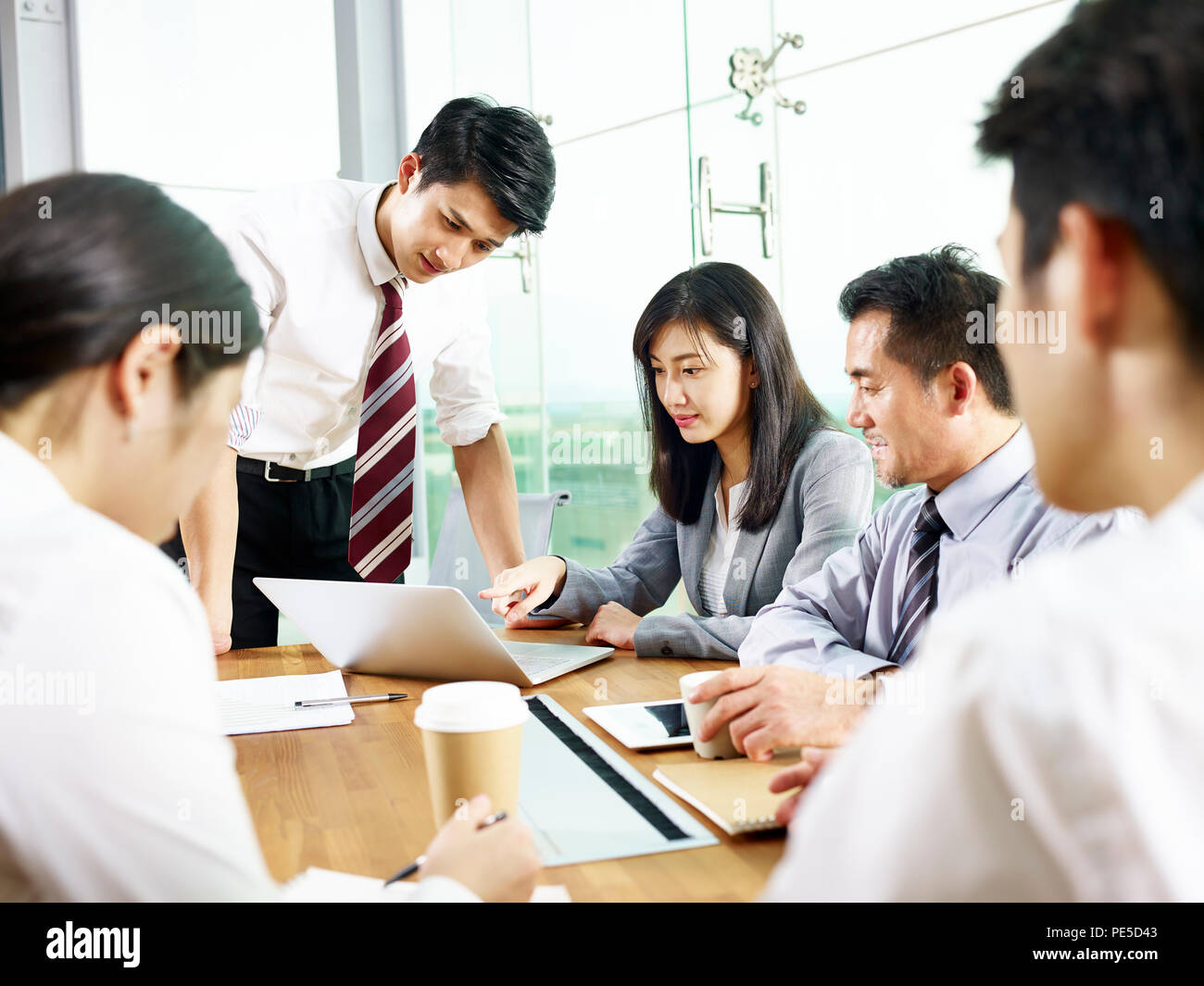 team of asian businessmen and businesswomen meeting in modern office ...