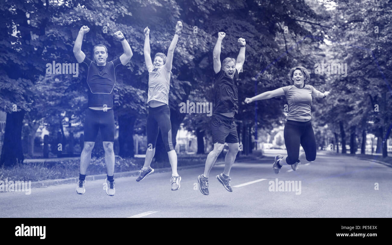 group of healthy runners team jumping in the air at city park during ...