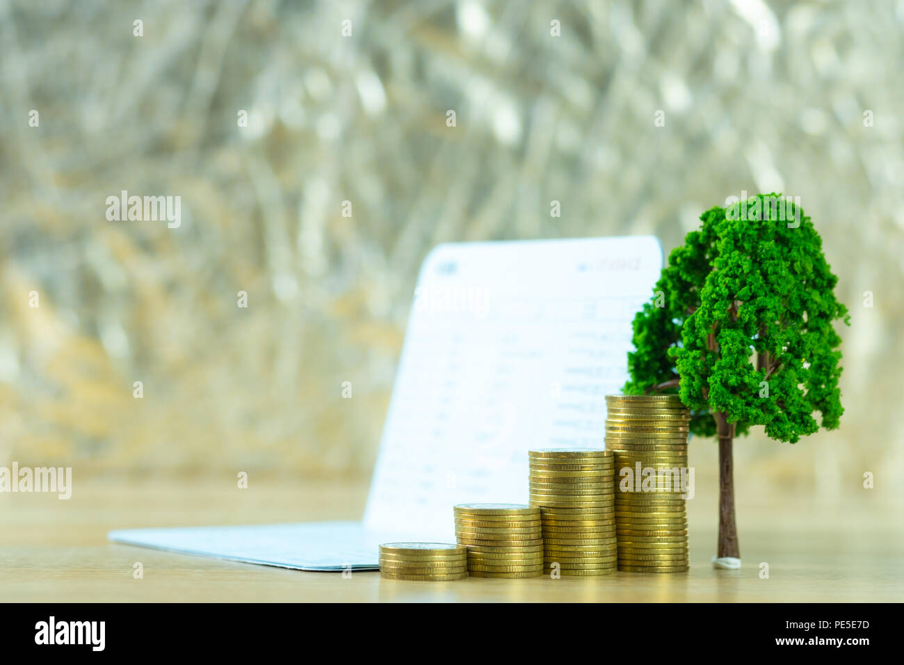 Little tree growing up from coin stack and passbook or account book ...