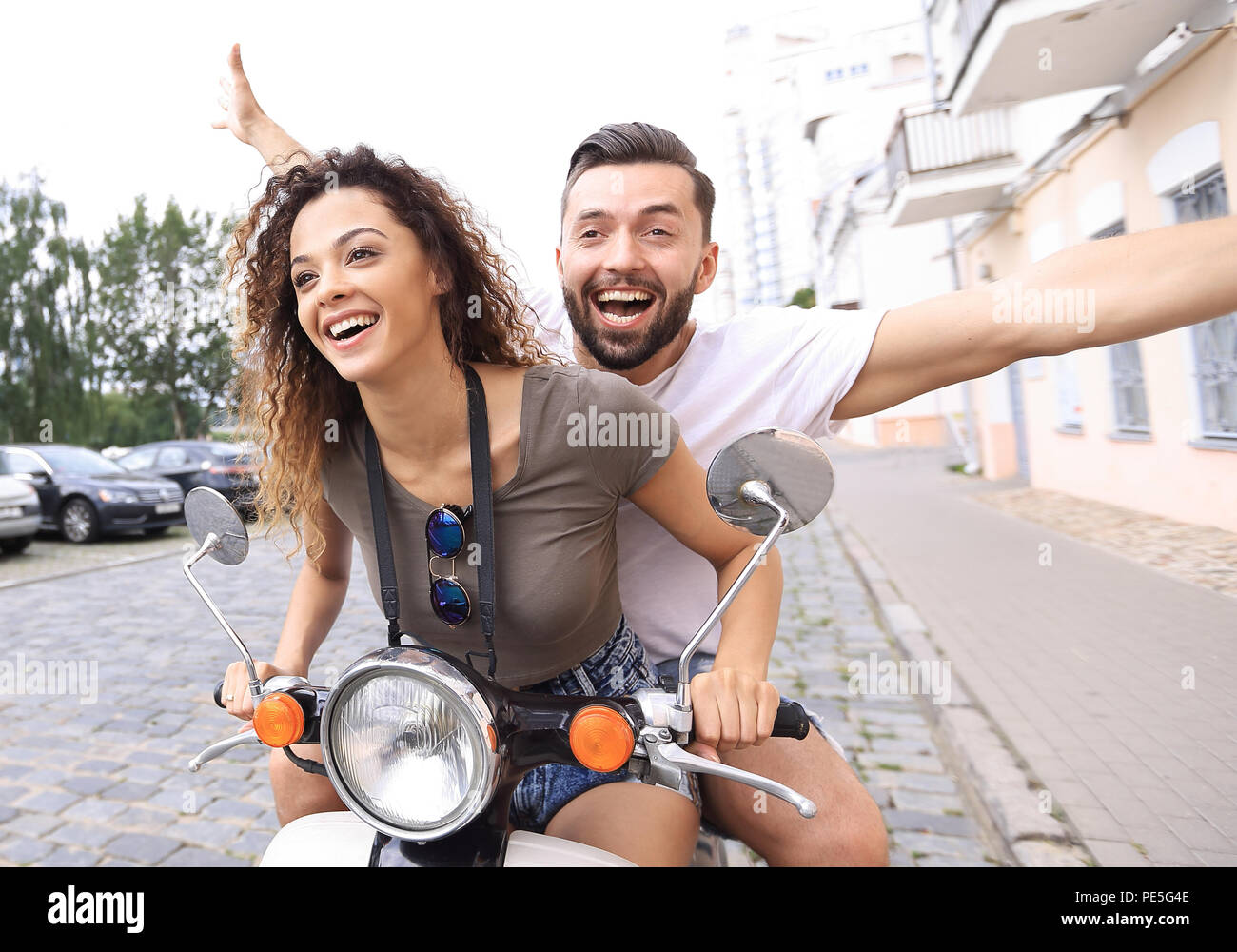 Couple riding motor scooter in old city street Stock Photo - Alamy
