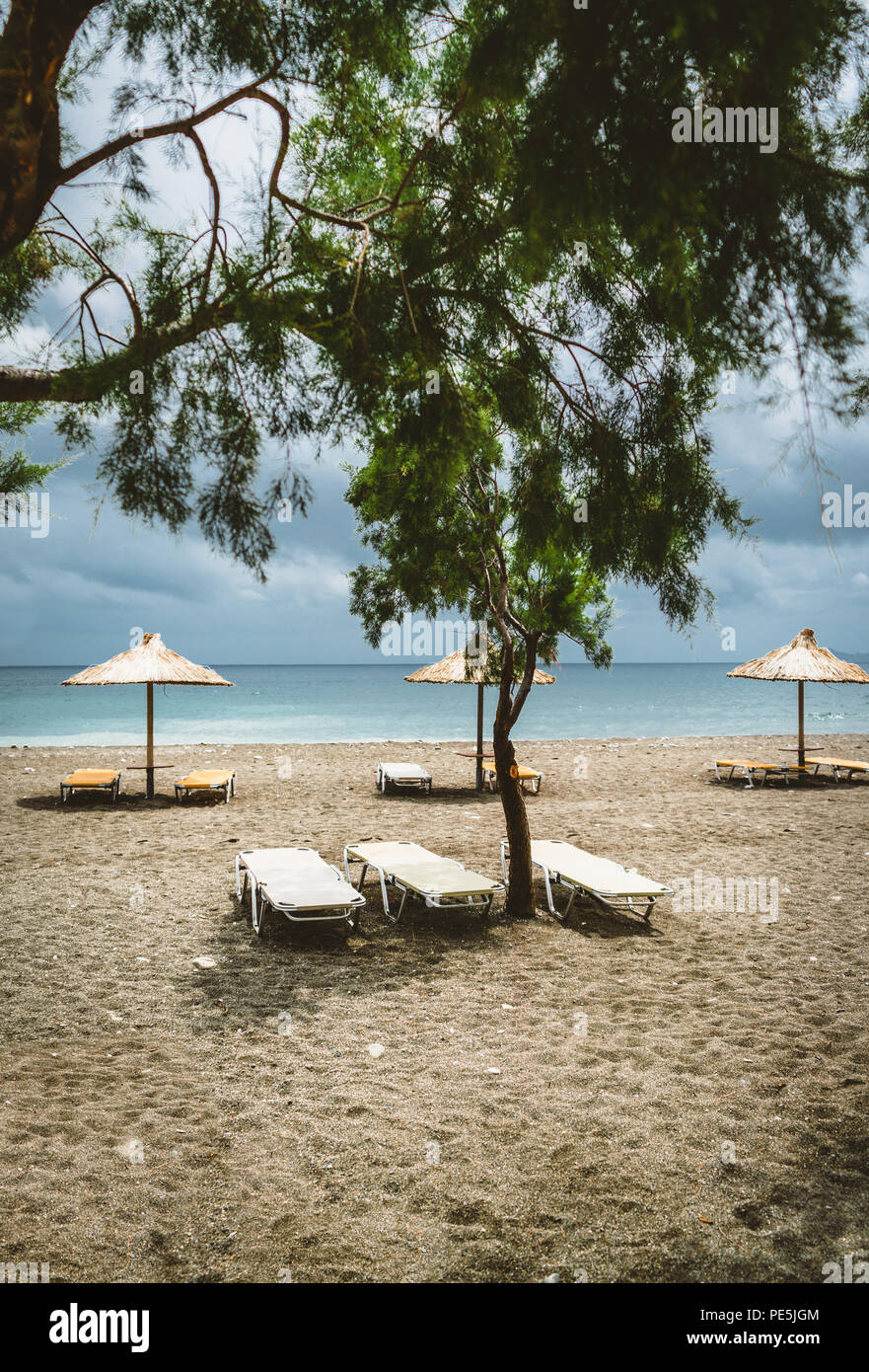 Typical beach scene in island crete. View towards ocean. with sunbeds ...