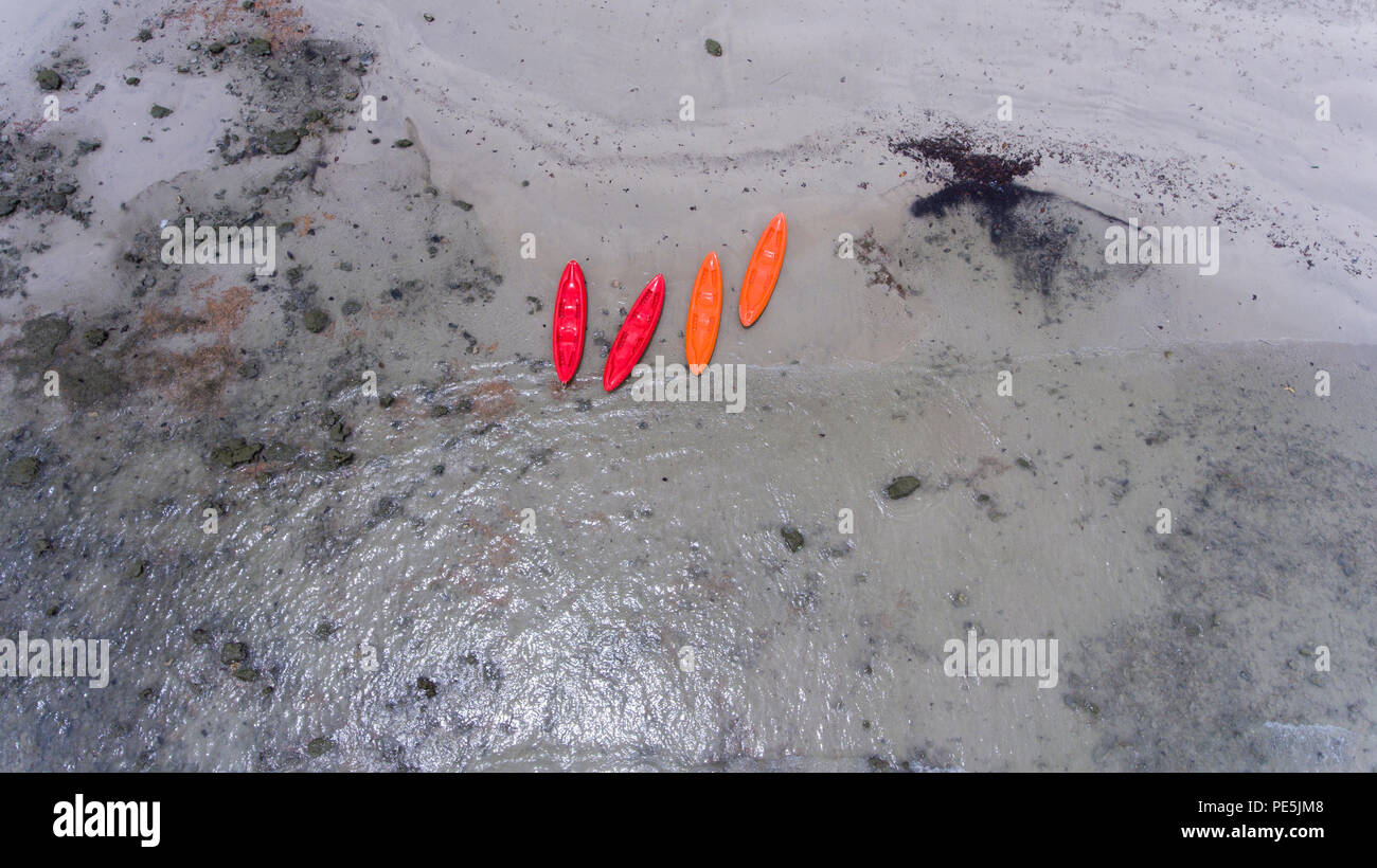 Orange and red kayaks on the beach shore Stock Photo - Alamy