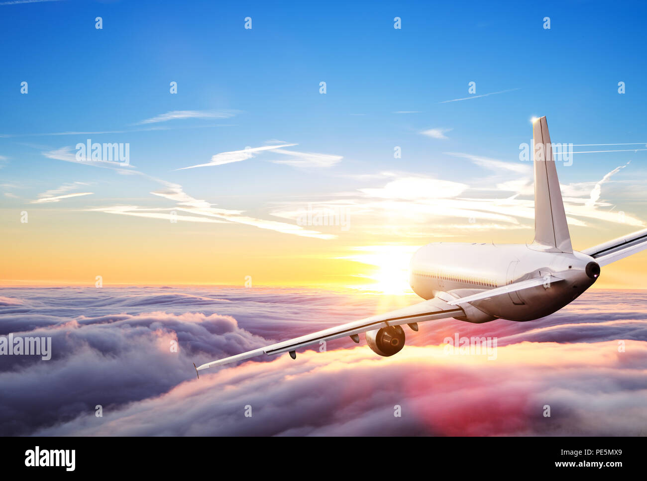 Back view of commercial airplane flying above clouds. Panoramic size ...