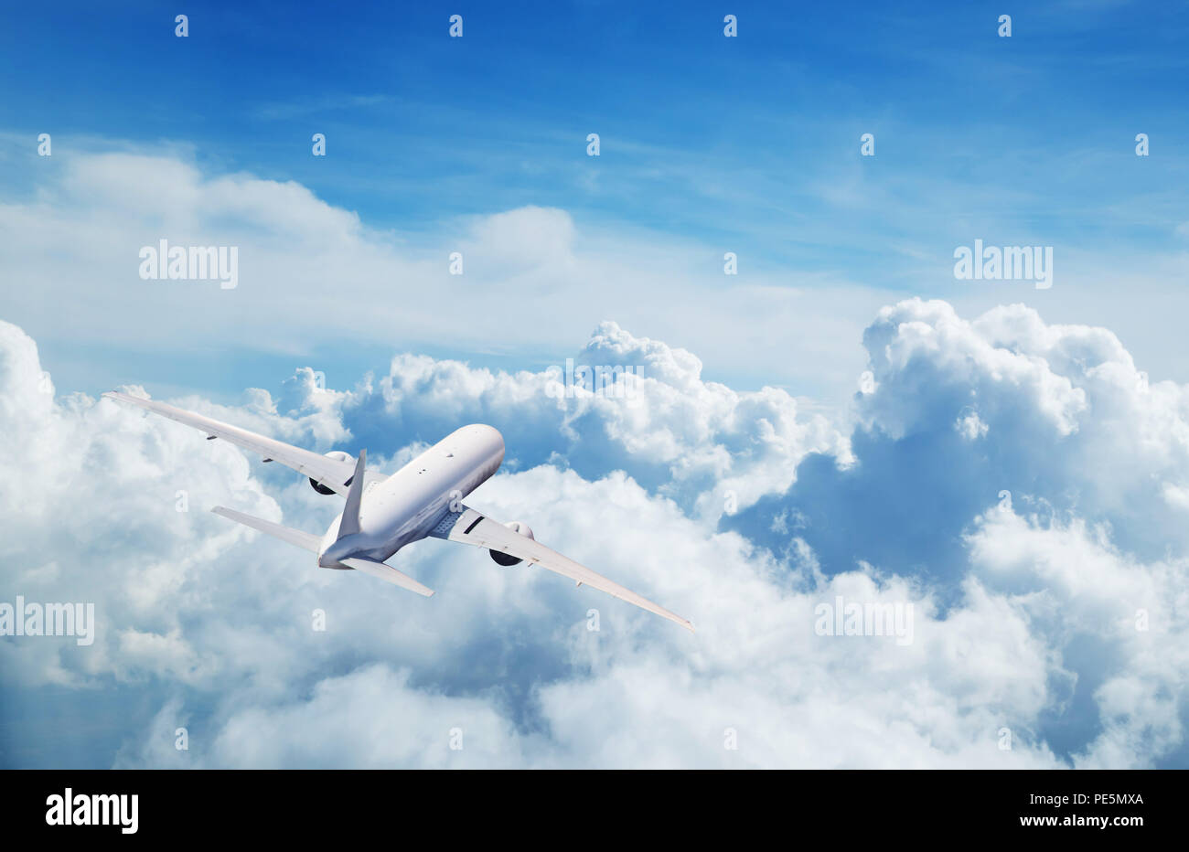 Back view of commercial airplane flying above clouds. Copyspace for ...