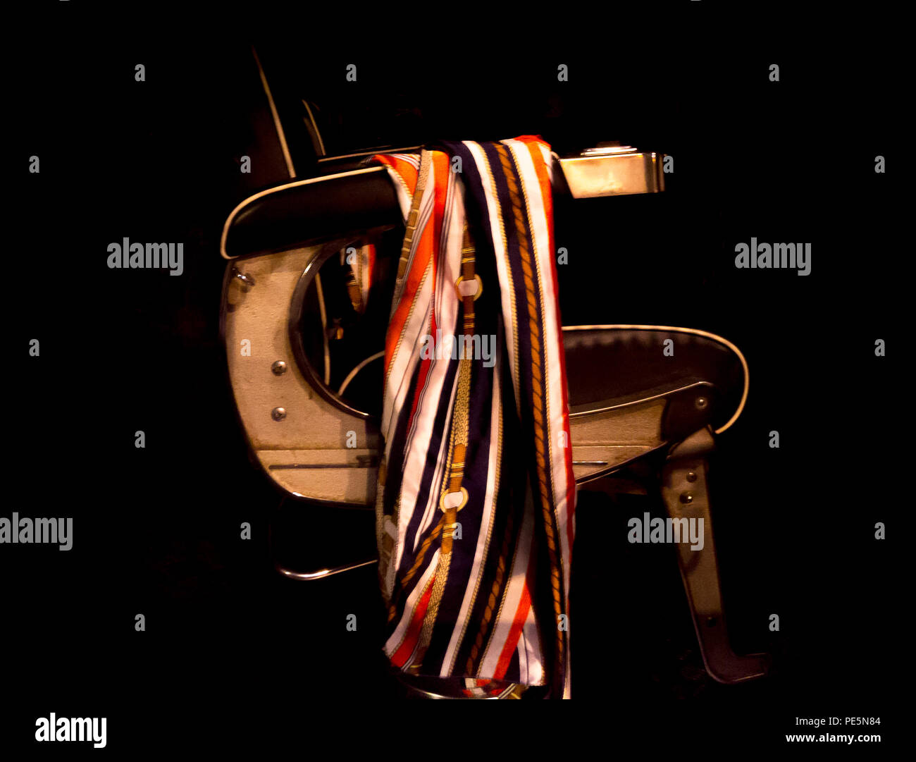 Colour image of a barber's chair with striped material draped over the ...