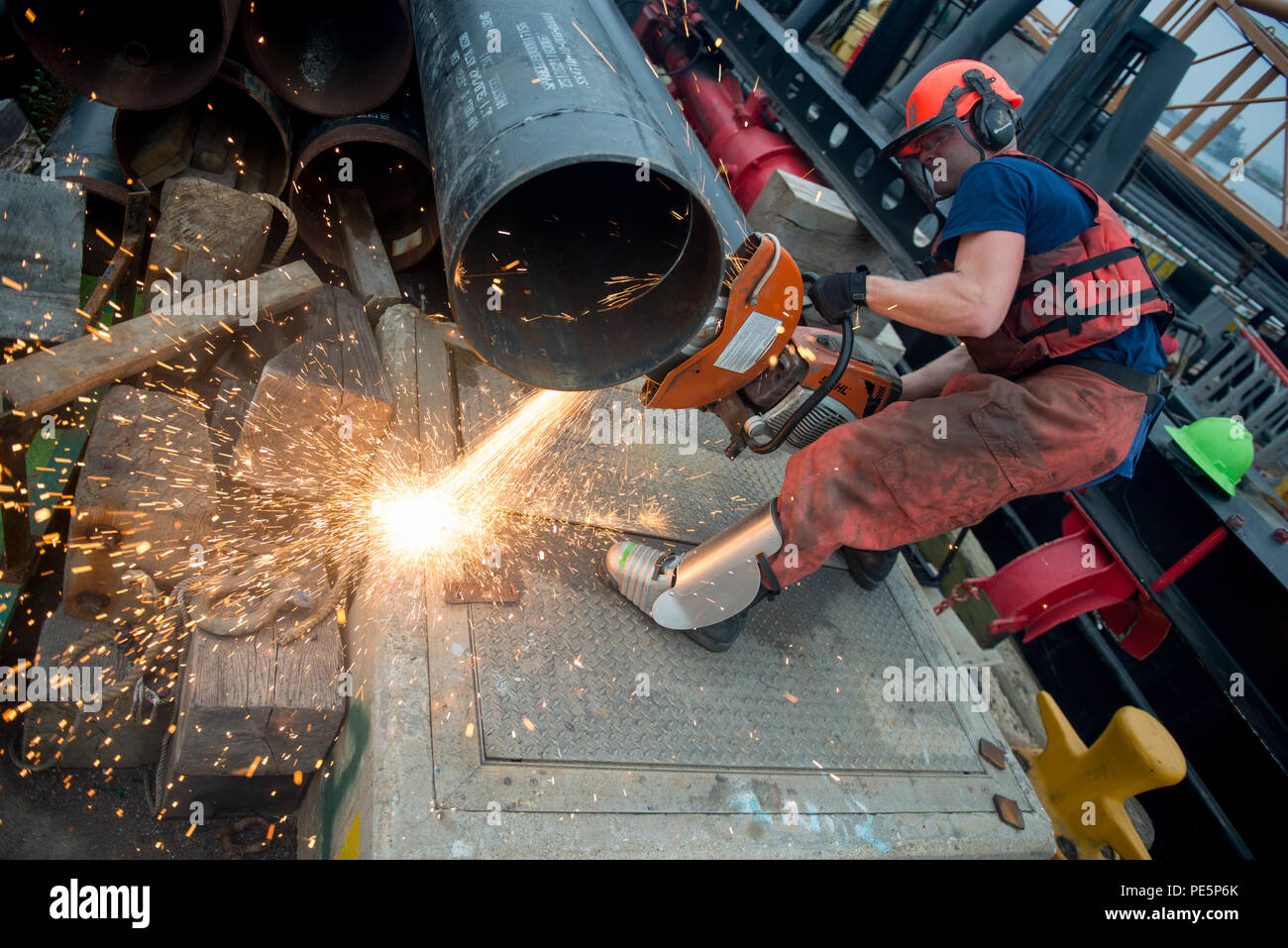 Fireman Apprentice John Perkins saws an 18-foot metal pipe used as ...