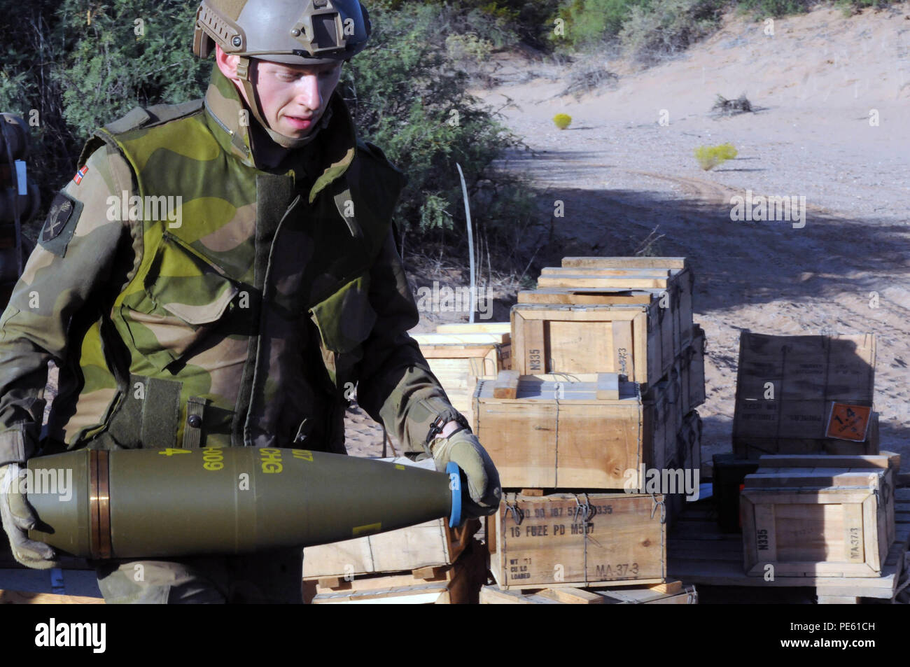 A Soldier from the Norwegian army carries a 155 mm howitzer round and ...