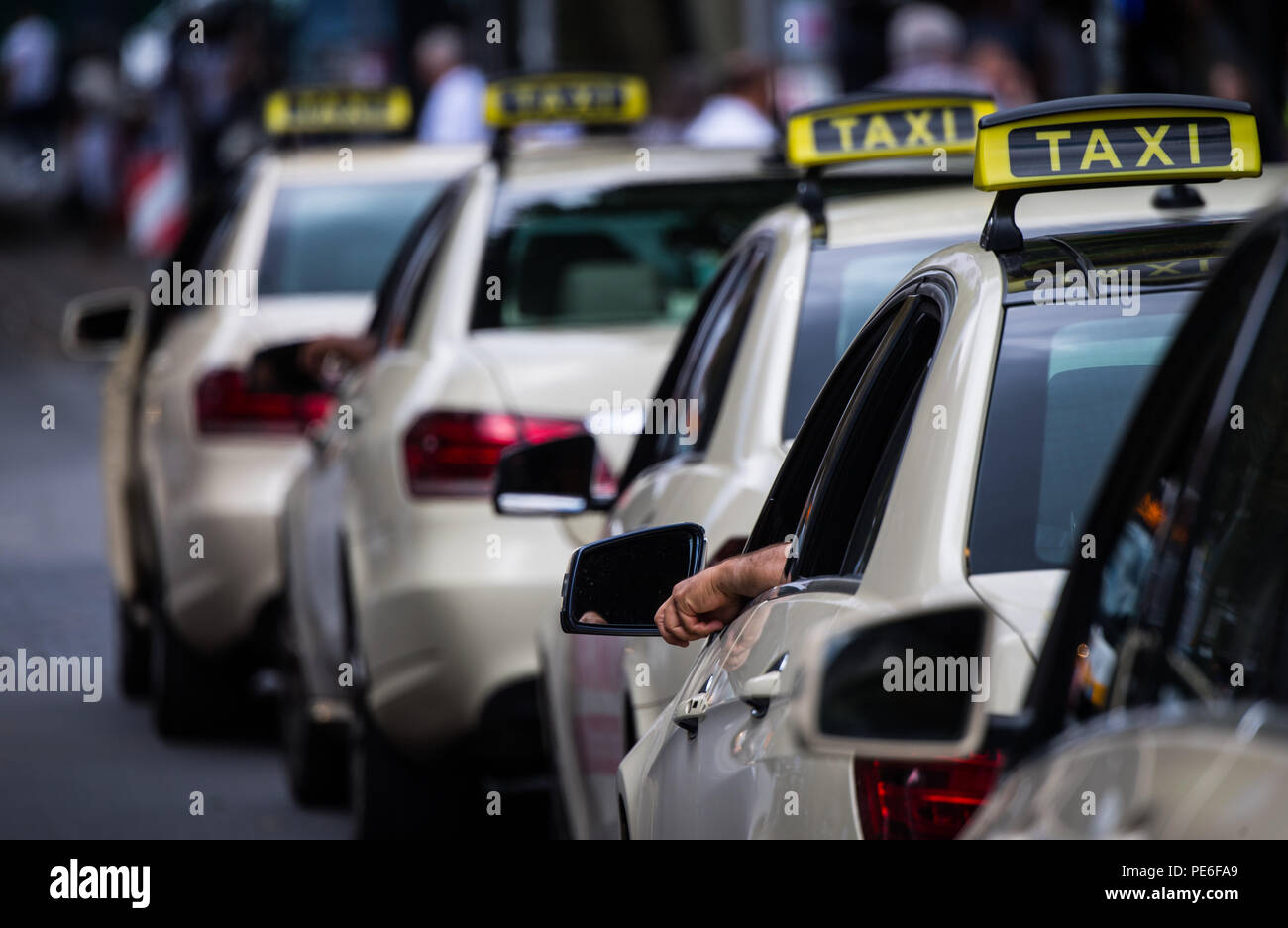 10 August 2018, Mainz, Germany: A taxi driver holds his hand out the ...