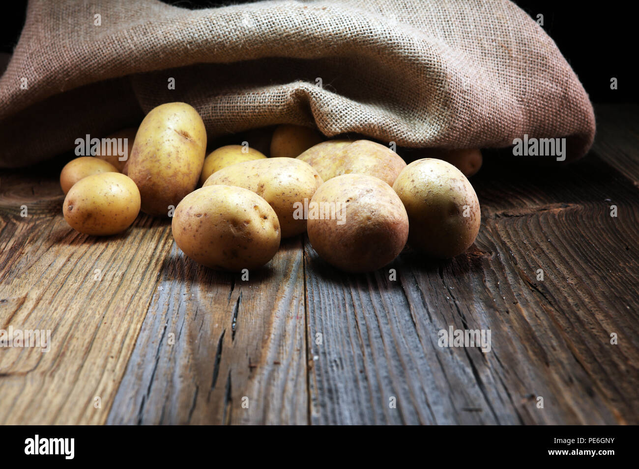 potato food . Fresh raw organic potatoes on old vintage background ...
