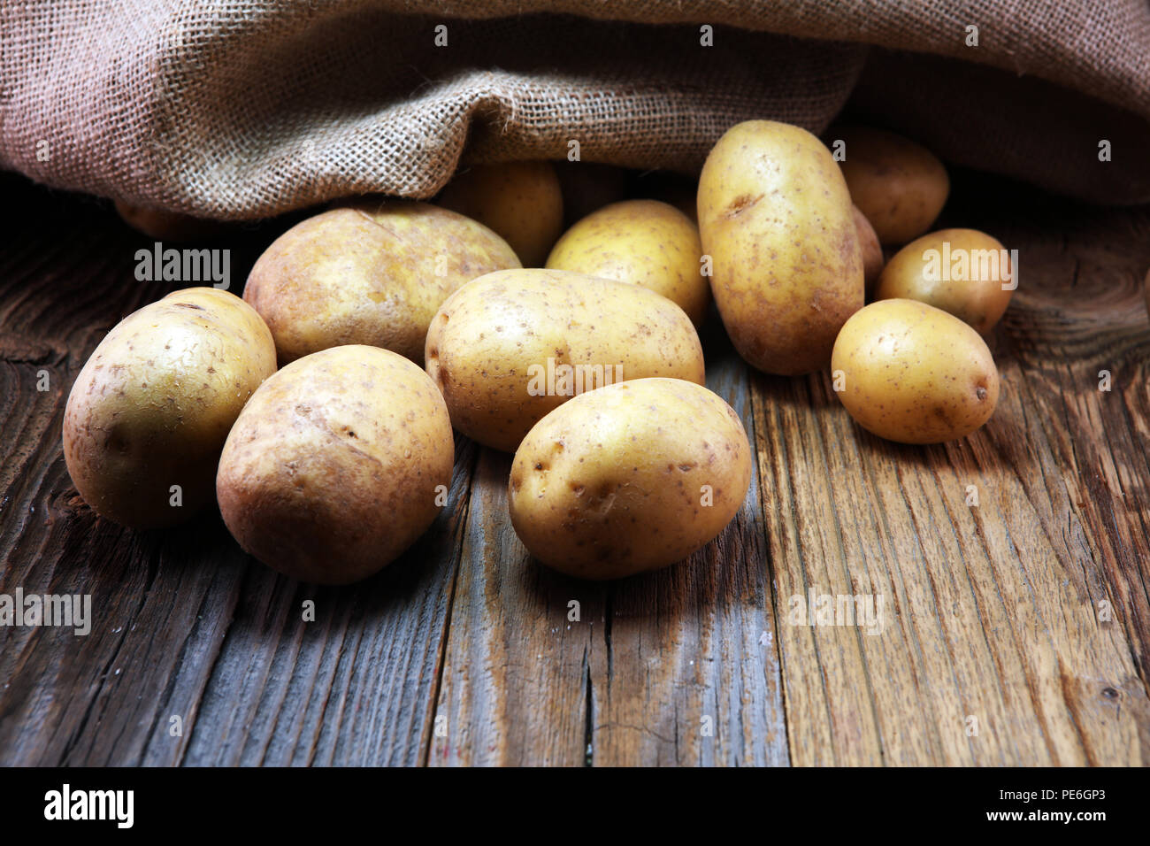 potato food . Fresh raw organic potatoes on old vintage background ...