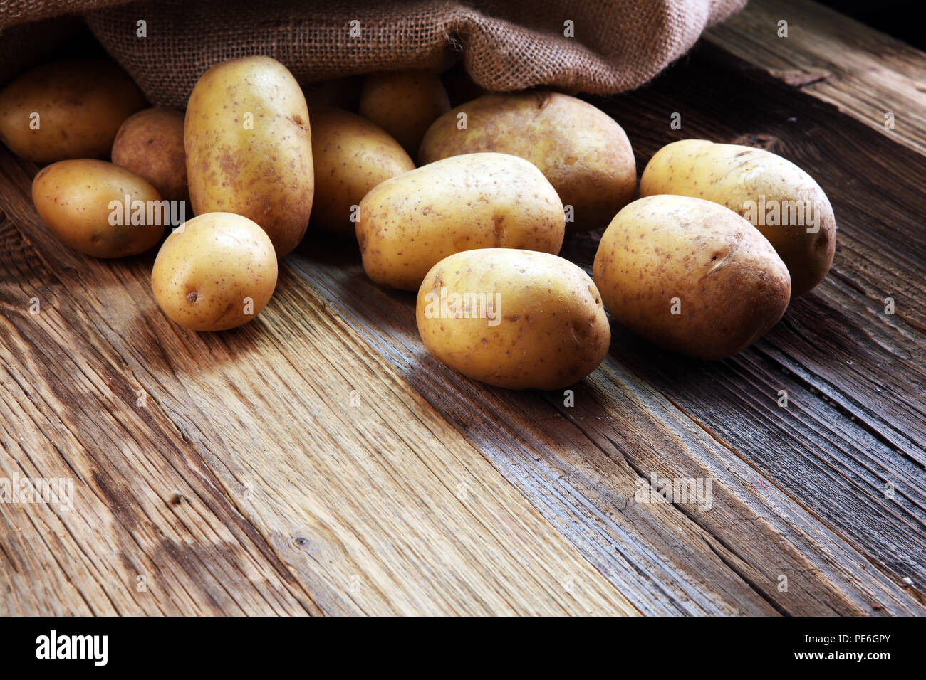 potato food . Fresh raw organic potatoes on old vintage background ...