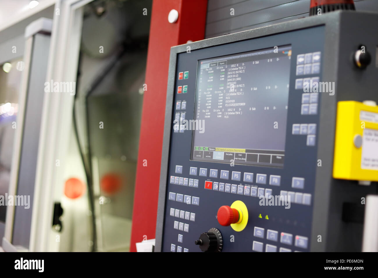 Metalworking machining center with CNC control panel on the foreground ...