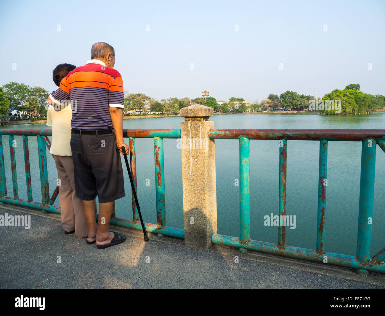 Happy romantic senior asian couple stand on the bridge in front of the ...