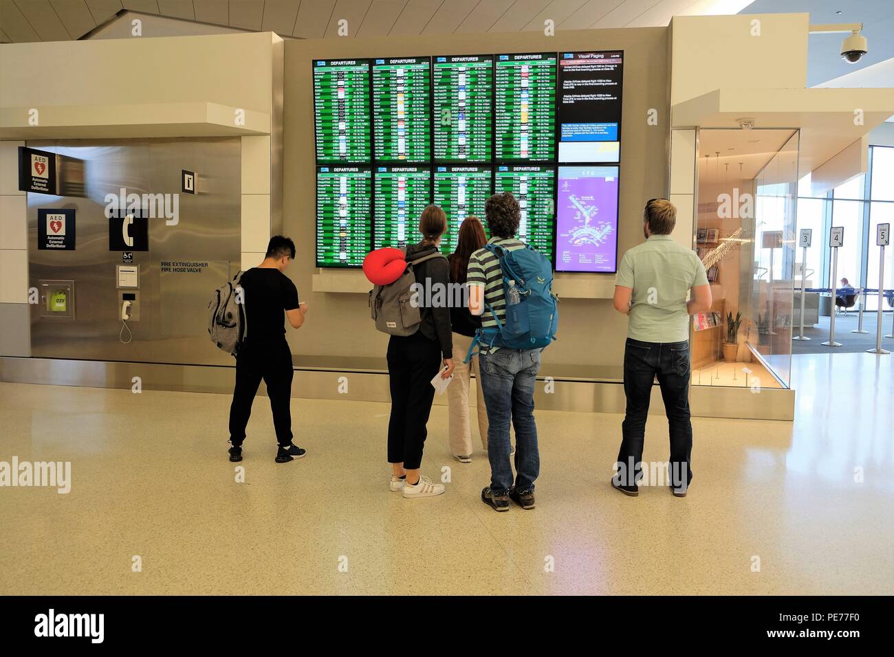 Passengers looking for flight departure and gate information on the ...