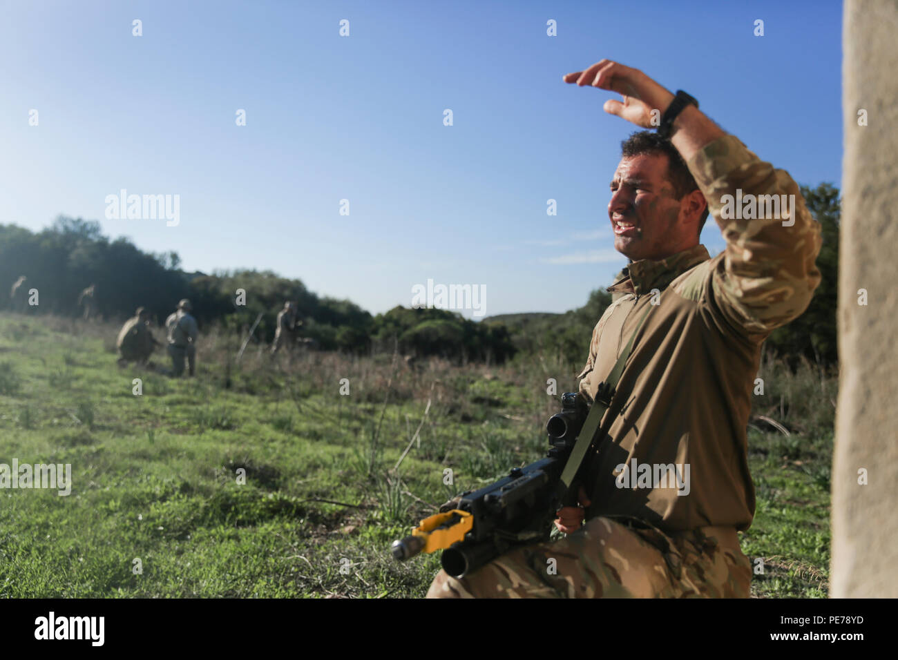 A Royal Marine with 45 Commando gives hand-and-arm signals to other ...