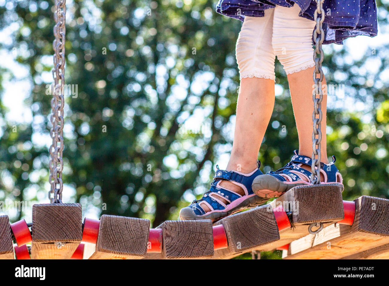 Little girl with sandal walking over bridge Stock Photo - Alamy