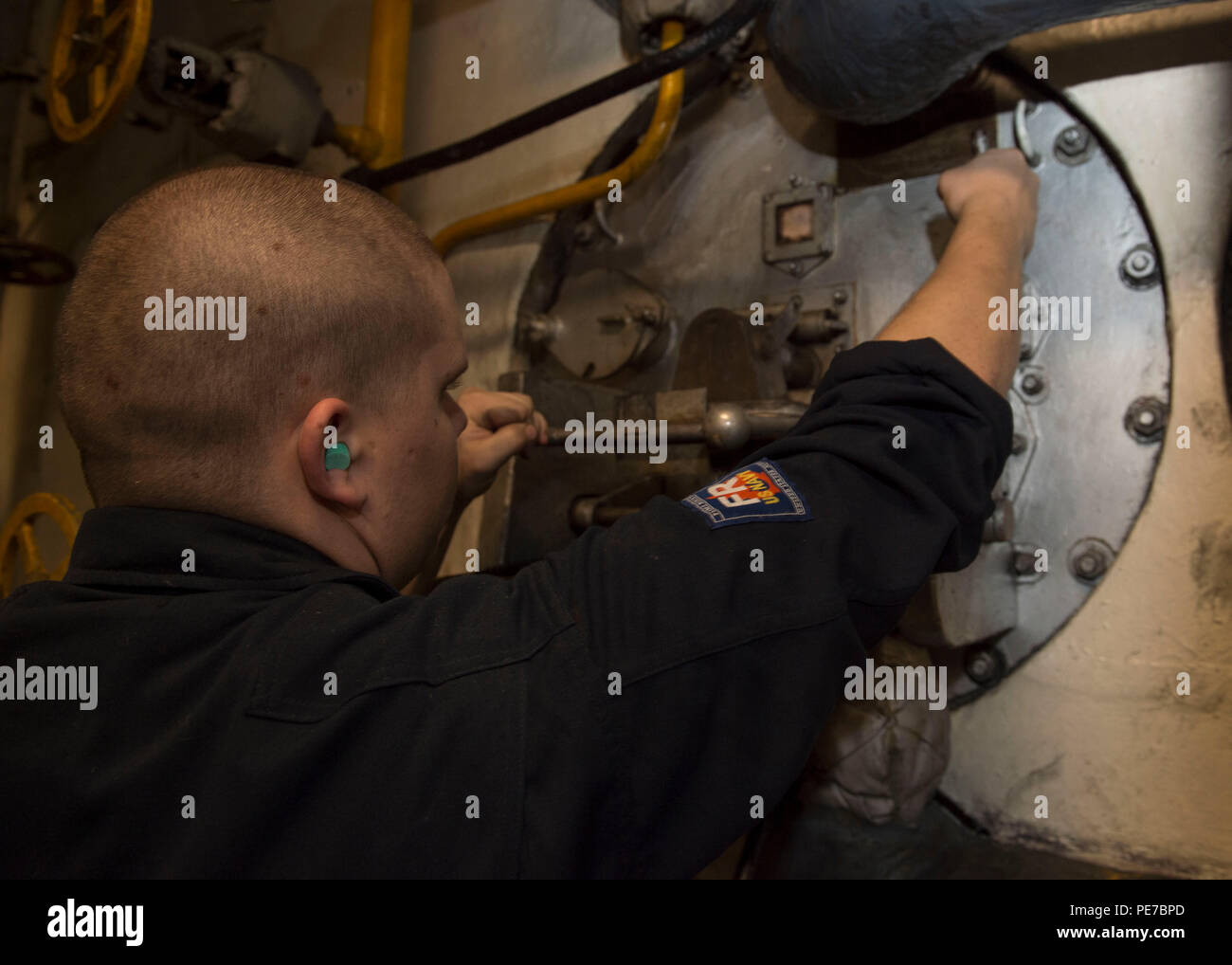 Fireman extinguishes a burner in the forward machinery room aboard the ...