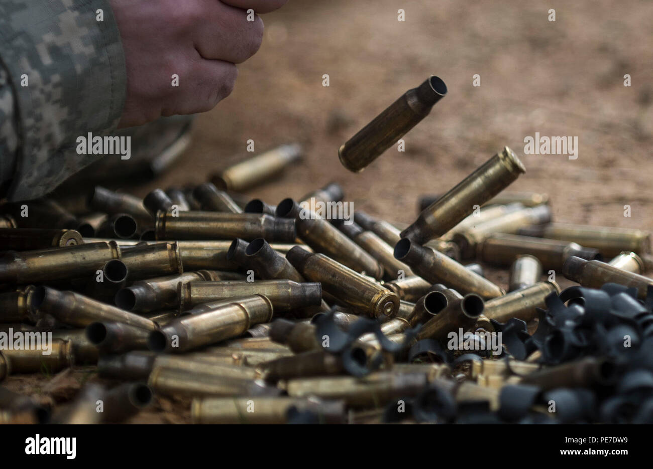Brass 7.62 mm shells eject from an M240B machine gun at a qualification ...