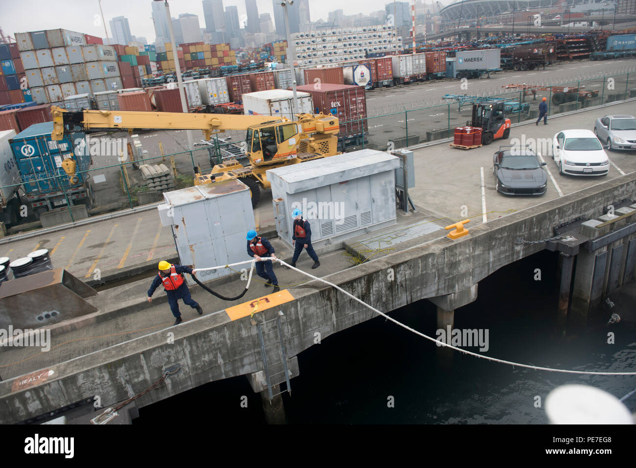 Coast Guardsmen at Coast Guard Base Seattle pull a hawser on the pier ...