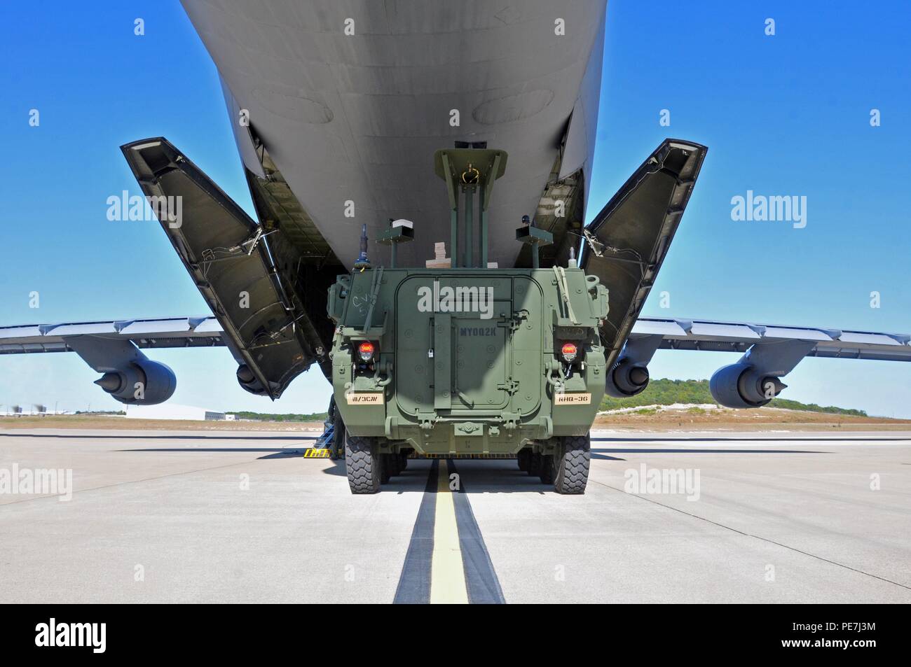 A C-5M Super Galaxy transport aircraft opens its rear doors to load ...