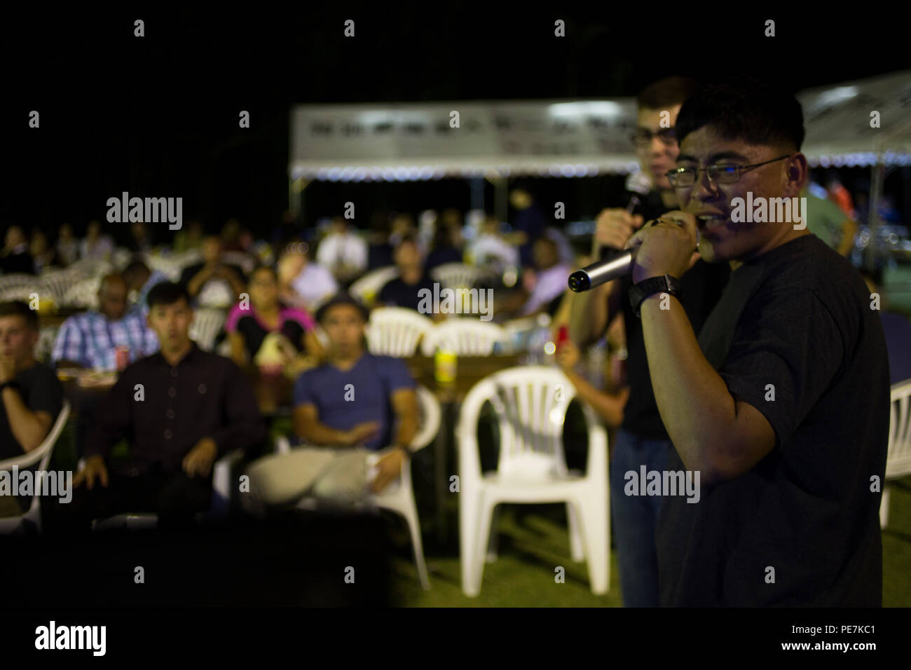 Lance Cpl. Trevor J. Newcomb, right, sings karaoke at a moon viewing ...