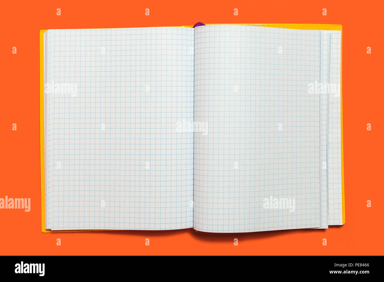opened workbook on an orange background Stock Photo - Alamy