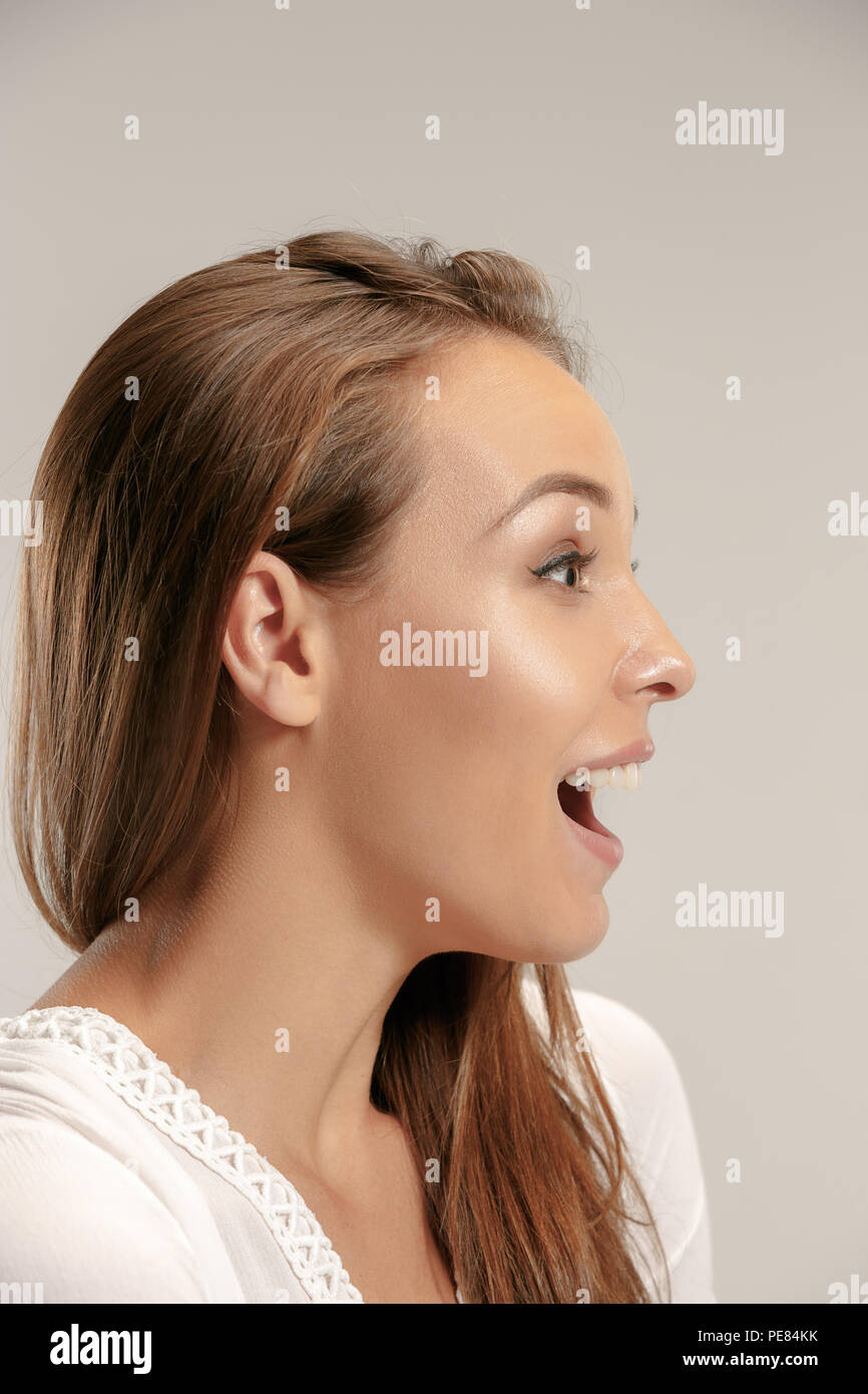 Wow. Beautiful female face isolated on gray studio backgroud. Young ...