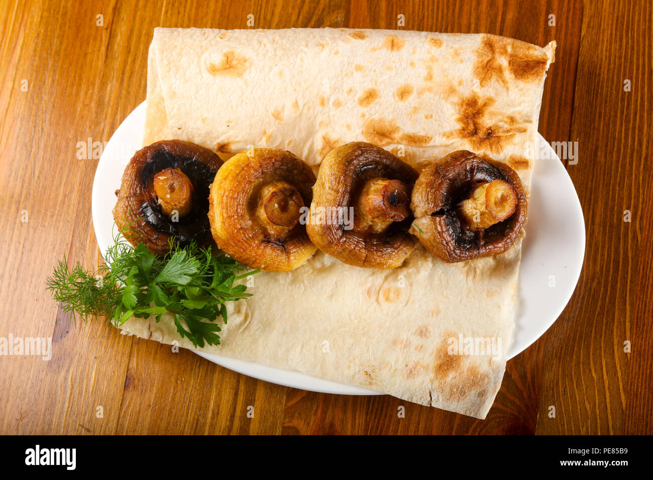 Grilled champignons with bread lavash Stock Photo - Alamy