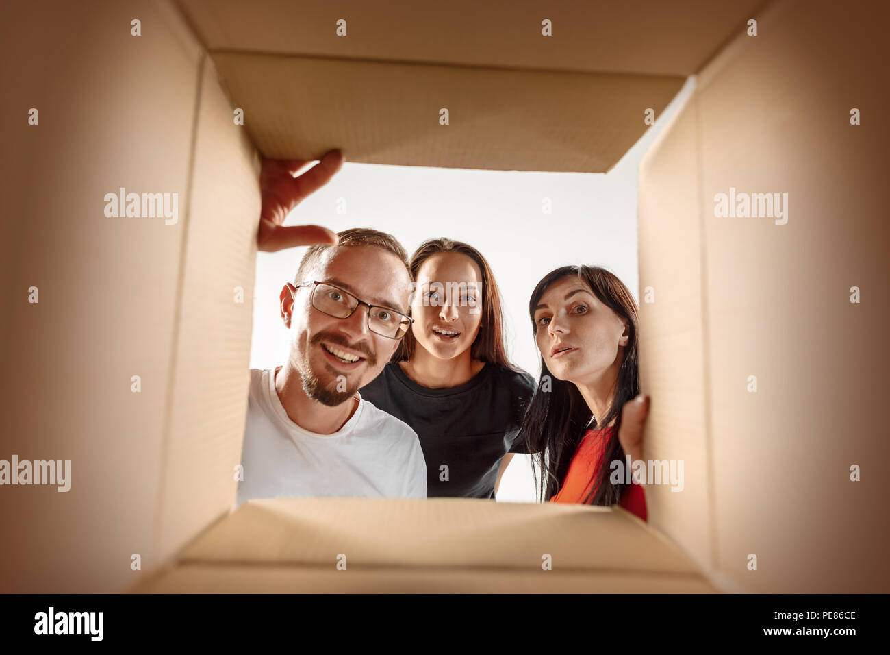 The surprised caucasian man and women opening carton box and looking ...