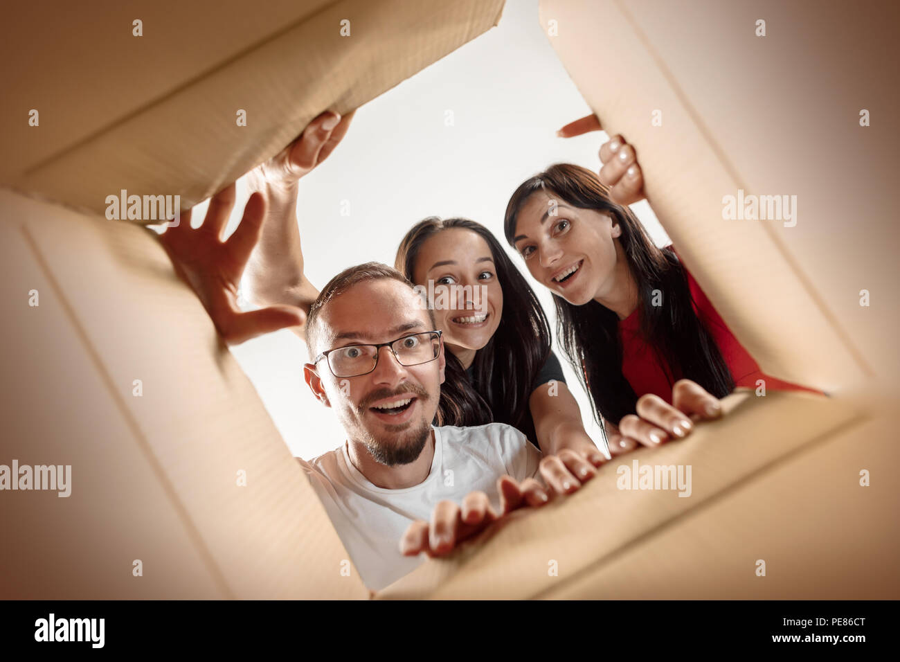 The surprised caucasian man and women opening carton box and looking ...