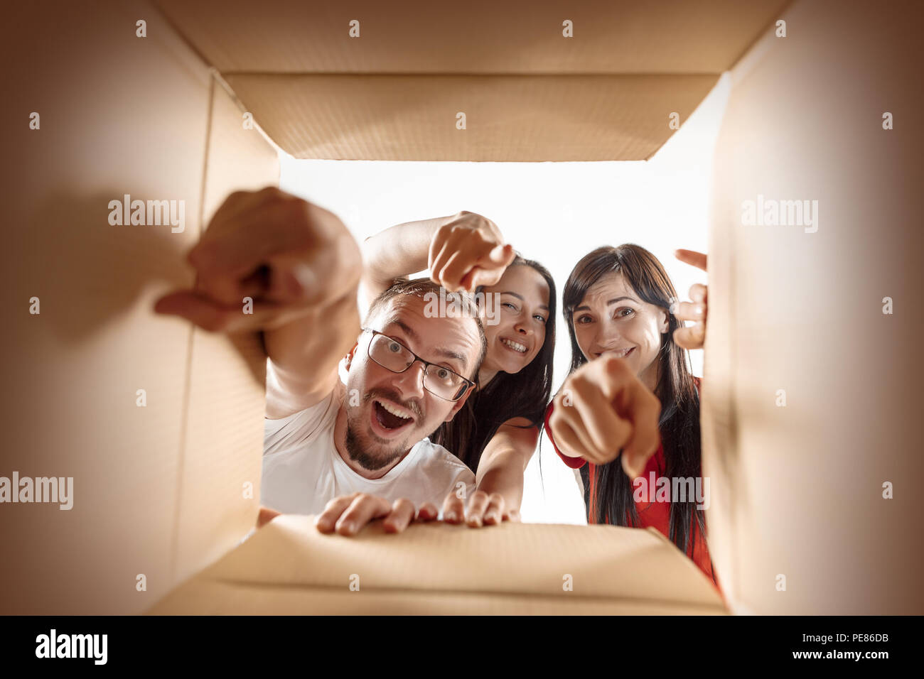 The surprised caucasian man and women opening carton box and looking ...