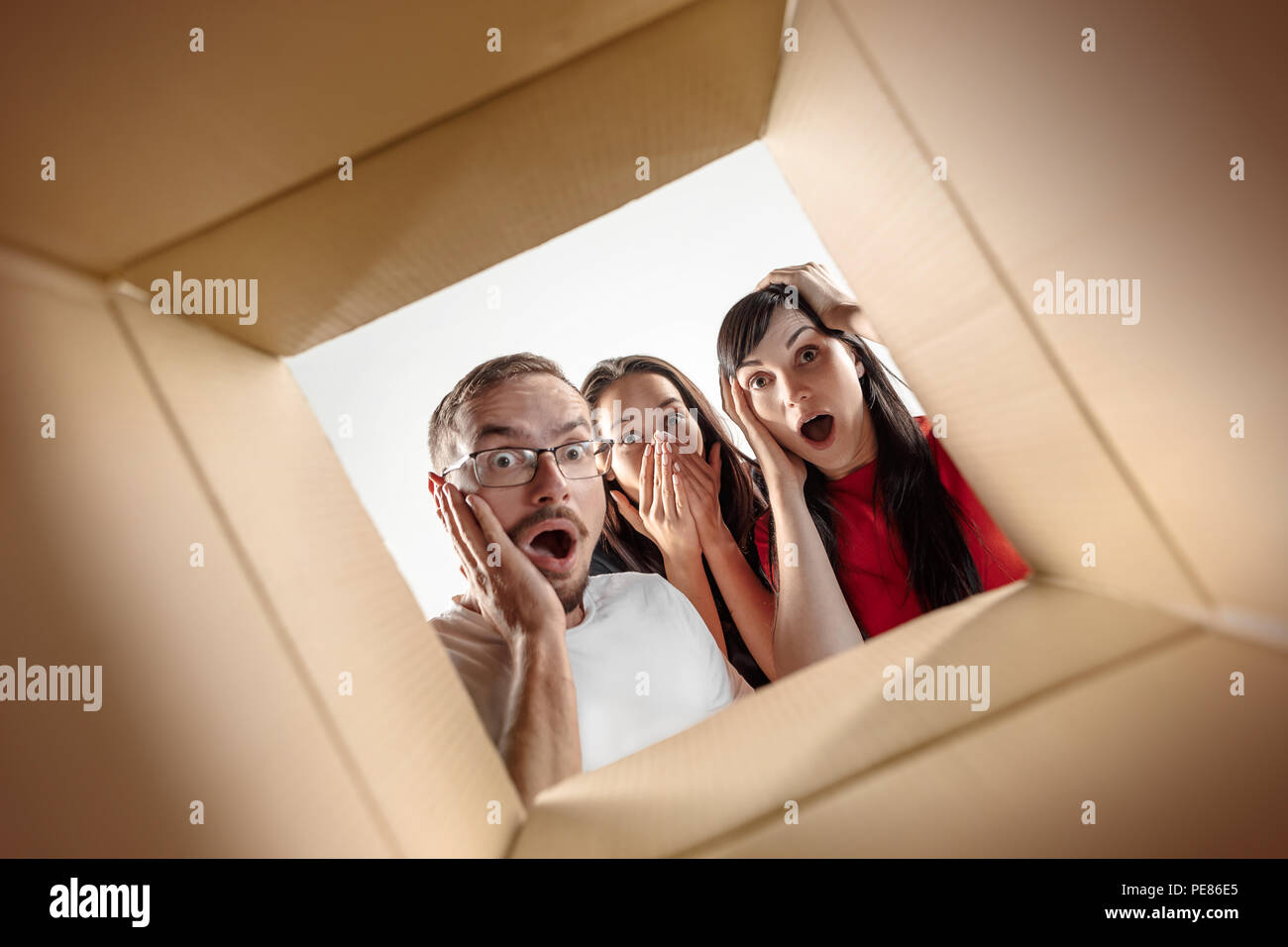 The surprised caucasian man and women opening carton box and looking ...