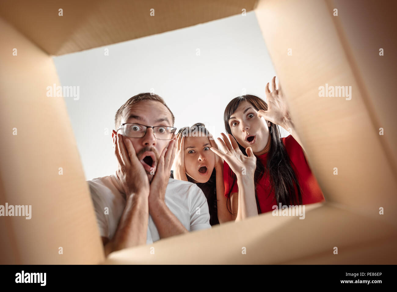 The surprised caucasian man and women opening carton box and looking ...