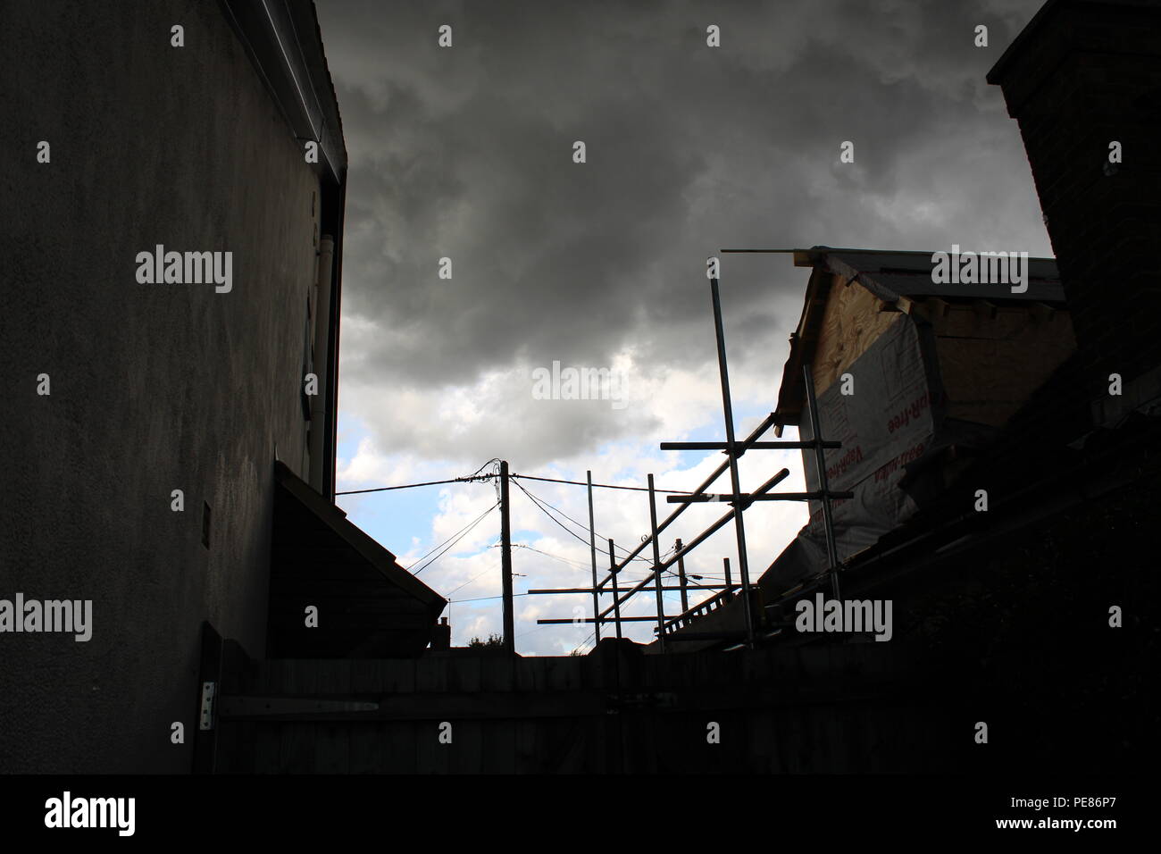 Storm Gathers over housing seen through scaffolding work Stock Photo ...