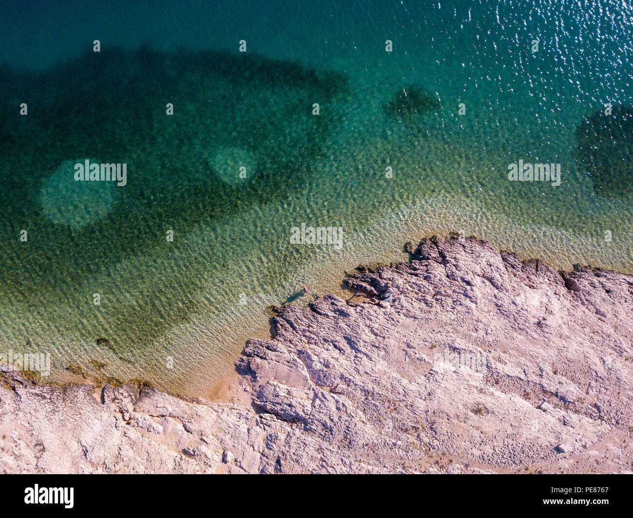 Aerial view of people moving among the rocks in the sea. Overview of ...