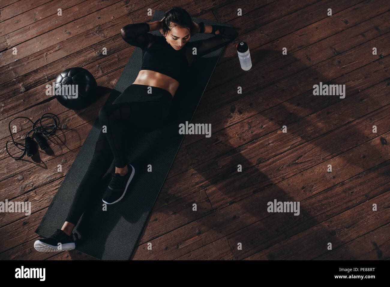 Overhead view of female doing abs workout at the gym. Muscular young ...