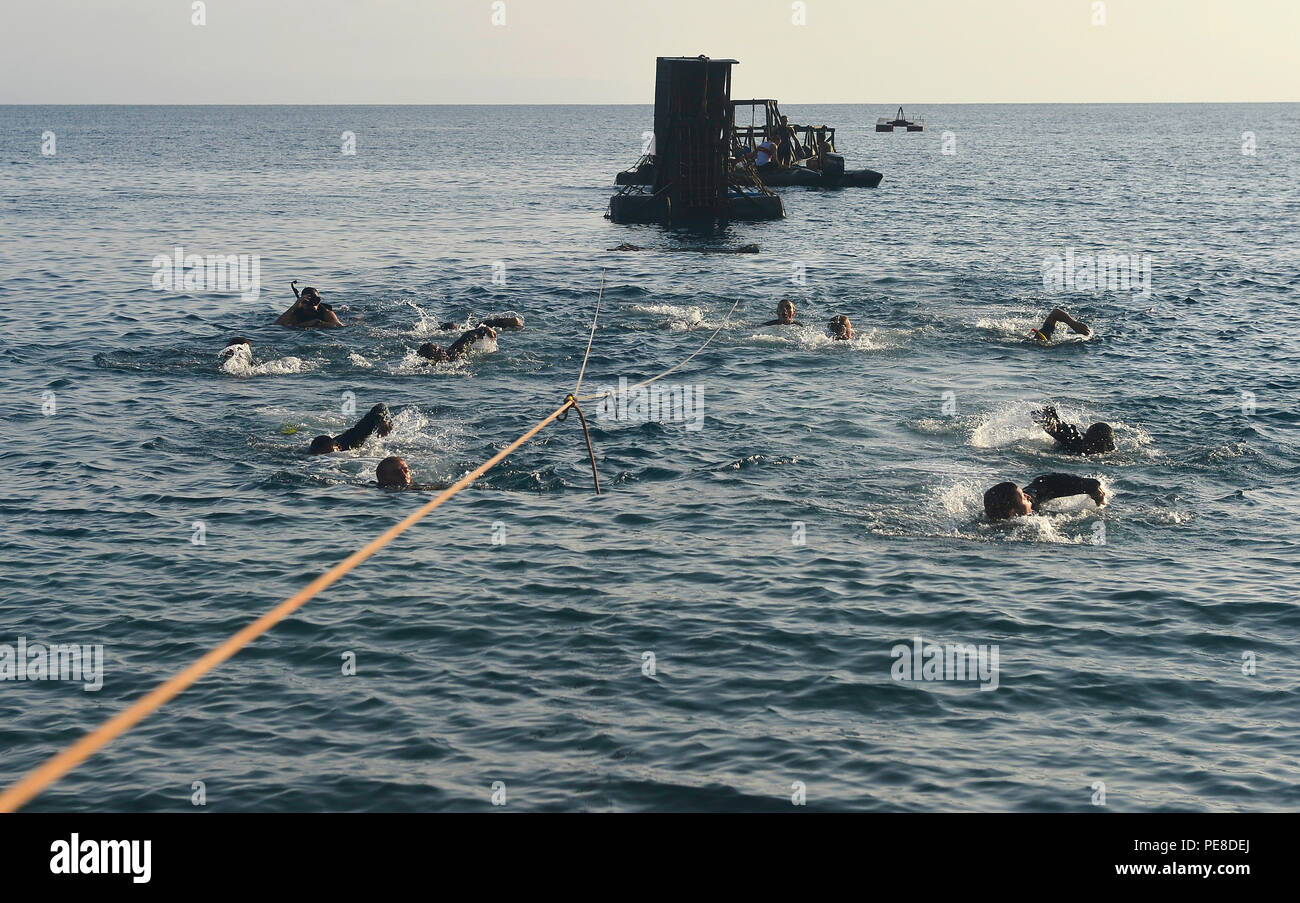 U.S. and French service members swim towards shore to complete the ...