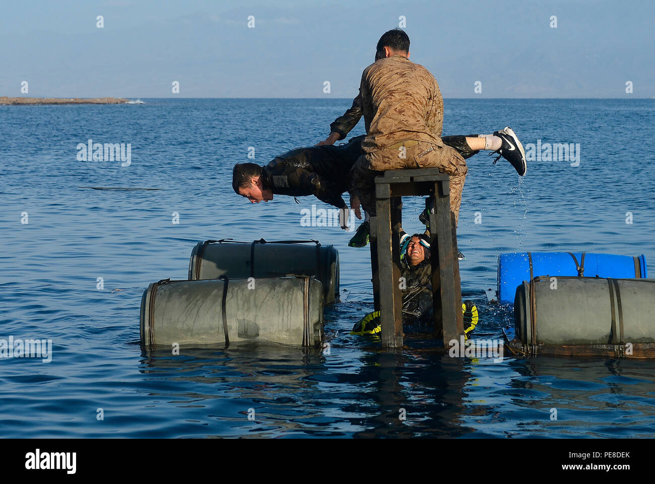 U.S. and French service members assist each other over water obstacles ...