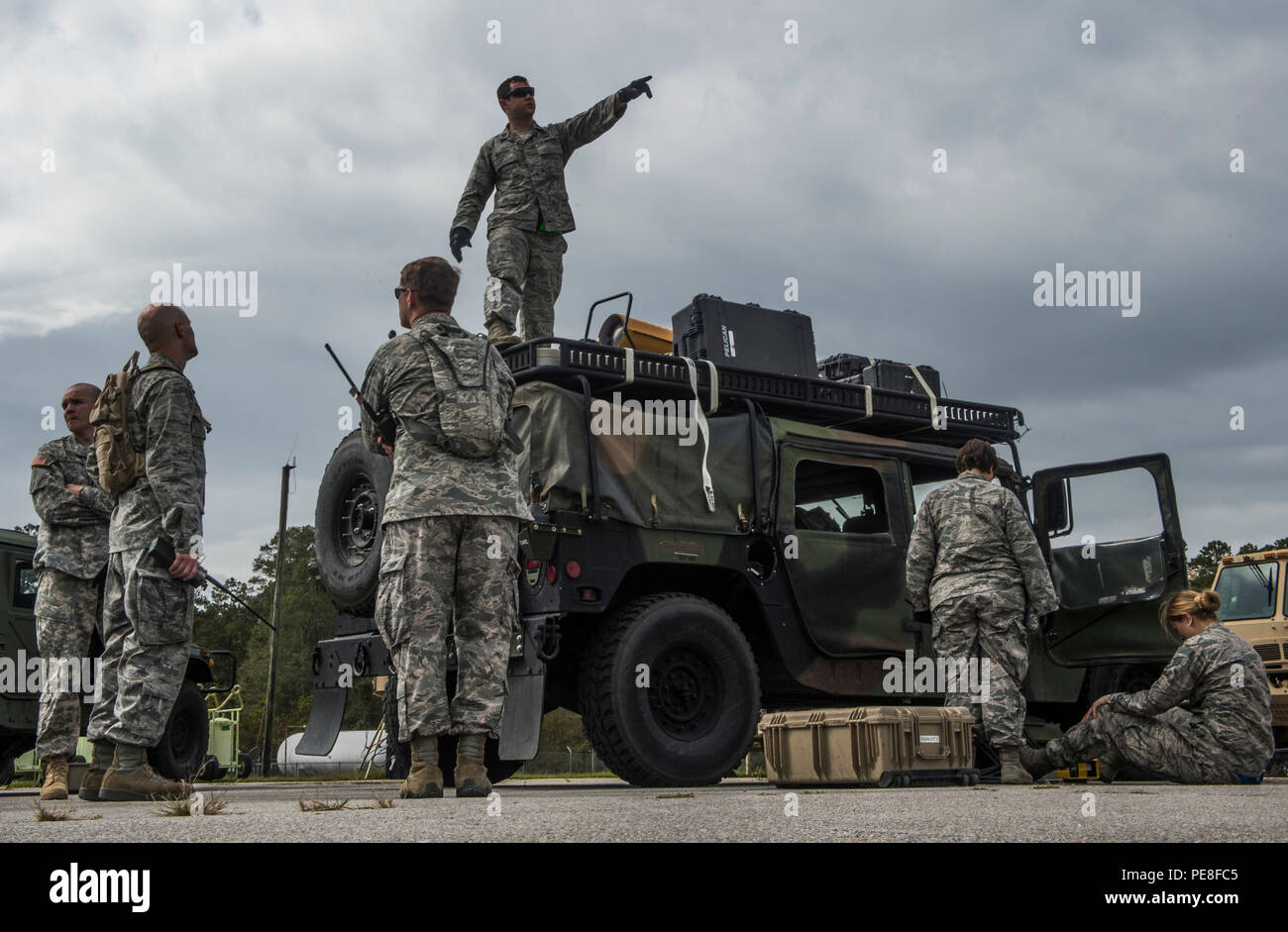 Capt. Christopher Nettles relays information on top of a vehicle to ...