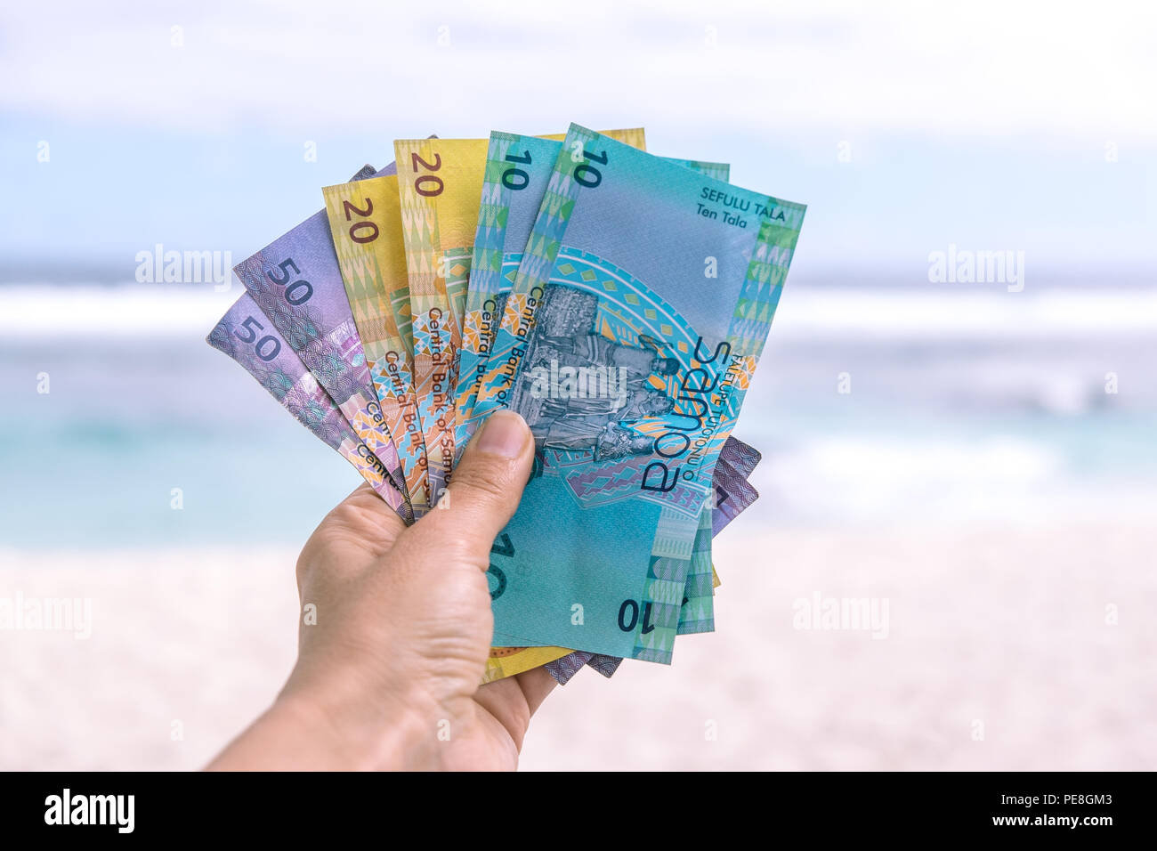Samoan Tala currency (WST) - left hand holding colorful bank notes from ...