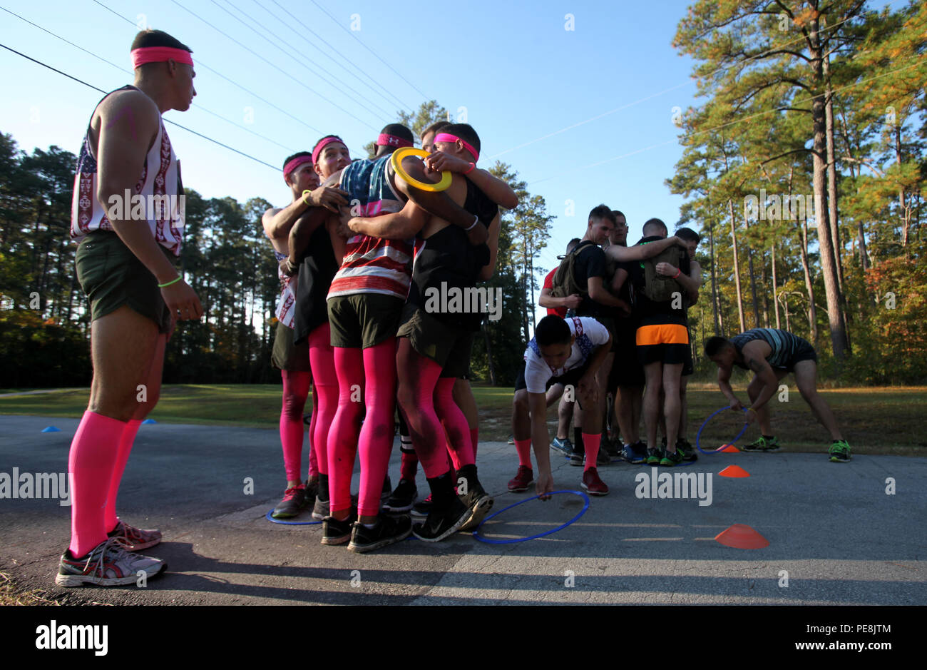 A team of service members huddle close to each other to complete a ...